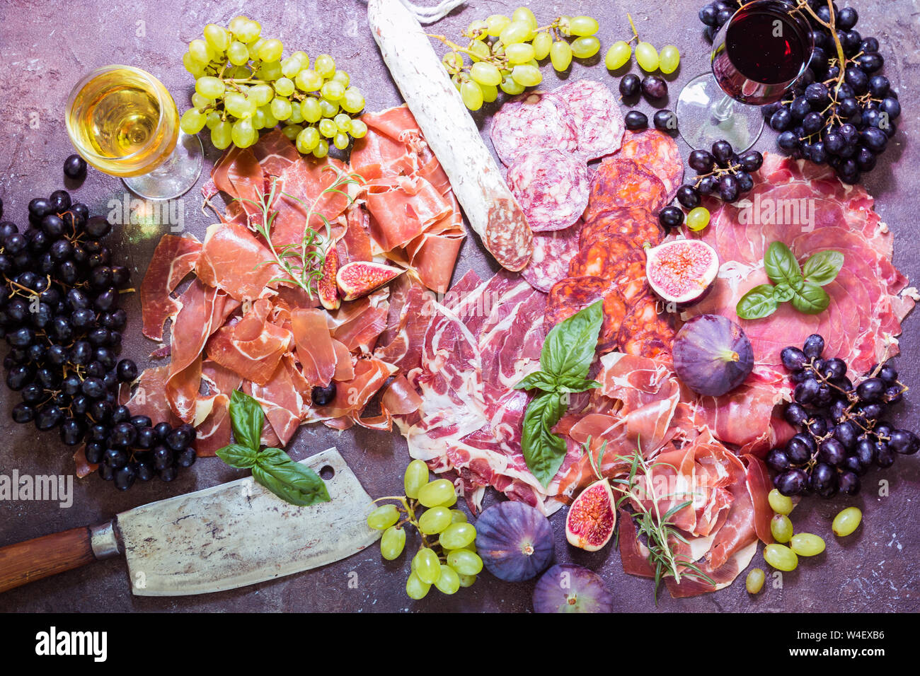 Different types jamon on cutting boardes with figs, grapes and wine ...