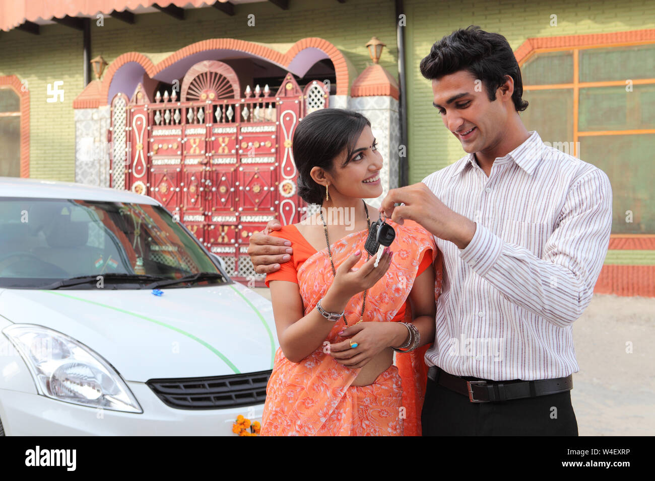Indian young man giving car key to his wife and smiling Stock Photo - Alamy