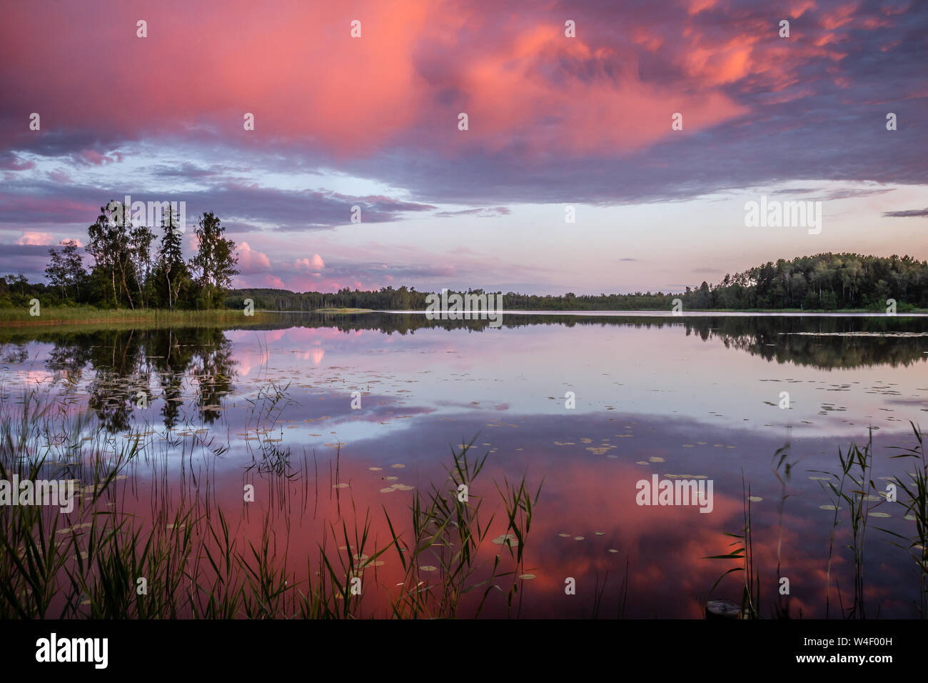 Reflection of purple sunset clouds in the lake Stock Photo - Alamy