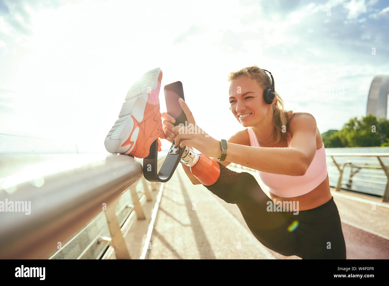 Staying in touch. Happy disabled woman in sportswear and headphones ...