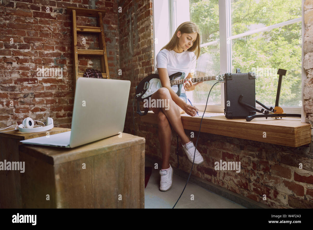 Woman in headphones recording music video blog home lesson, playing ...