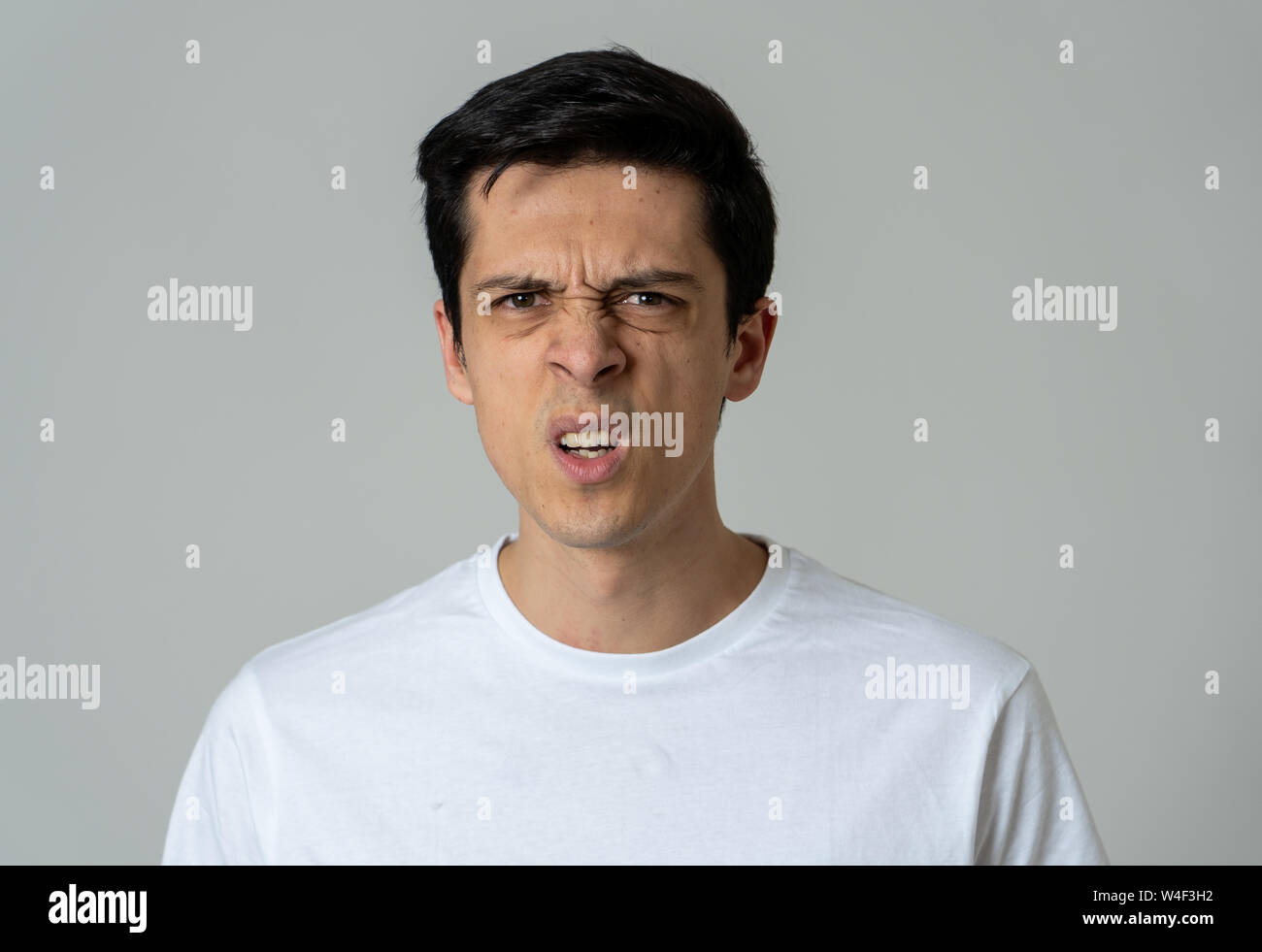 Close up of young caucasian male with an angry face. Looking displeased ...