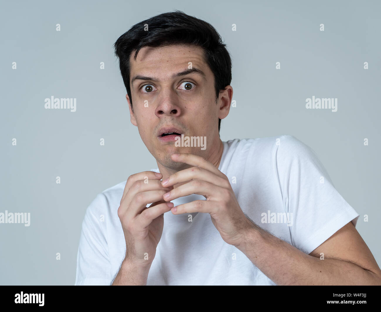 Young man feeling scared and shocked making fear, anxiety gestures. Looking terrified and ...