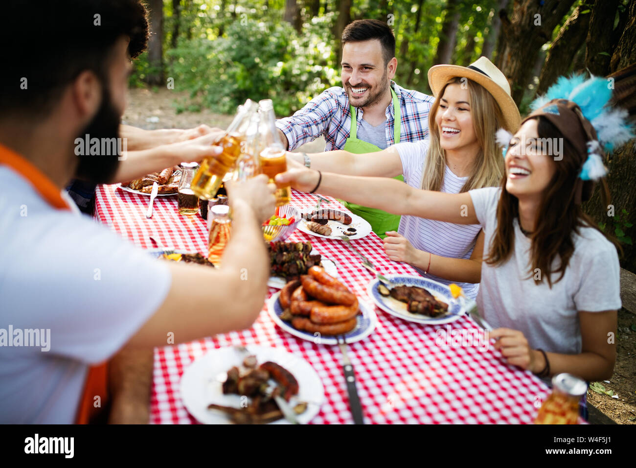 Happy friends camping and having a barbecue in nature Stock Photo - Alamy
