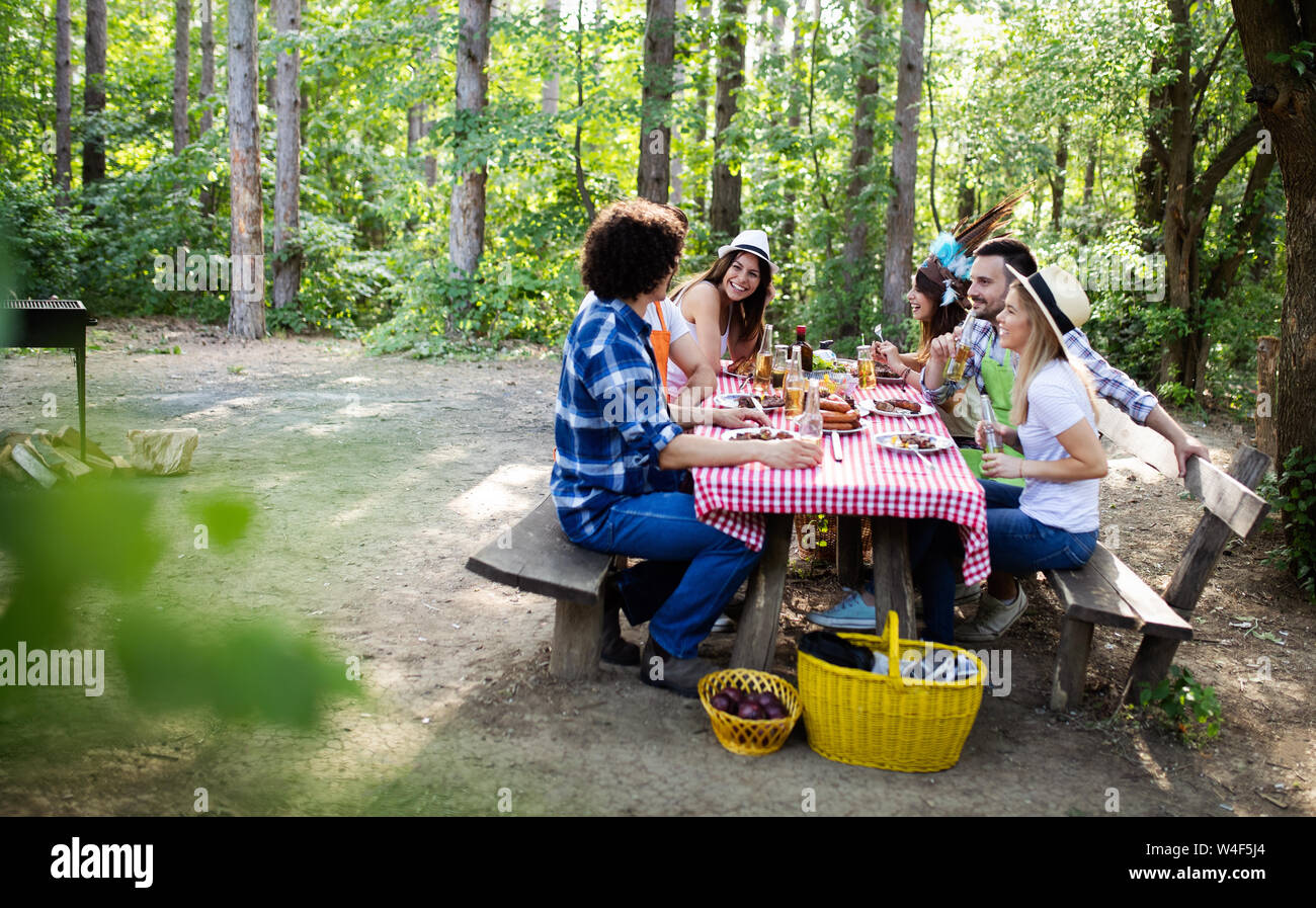 Happy friends camping and having a barbecue in nature Stock Photo - Alamy
