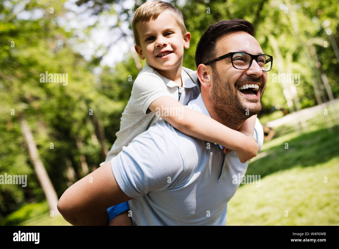 Father carrying his son on back and smiling outdoors Stock Photo - Alamy