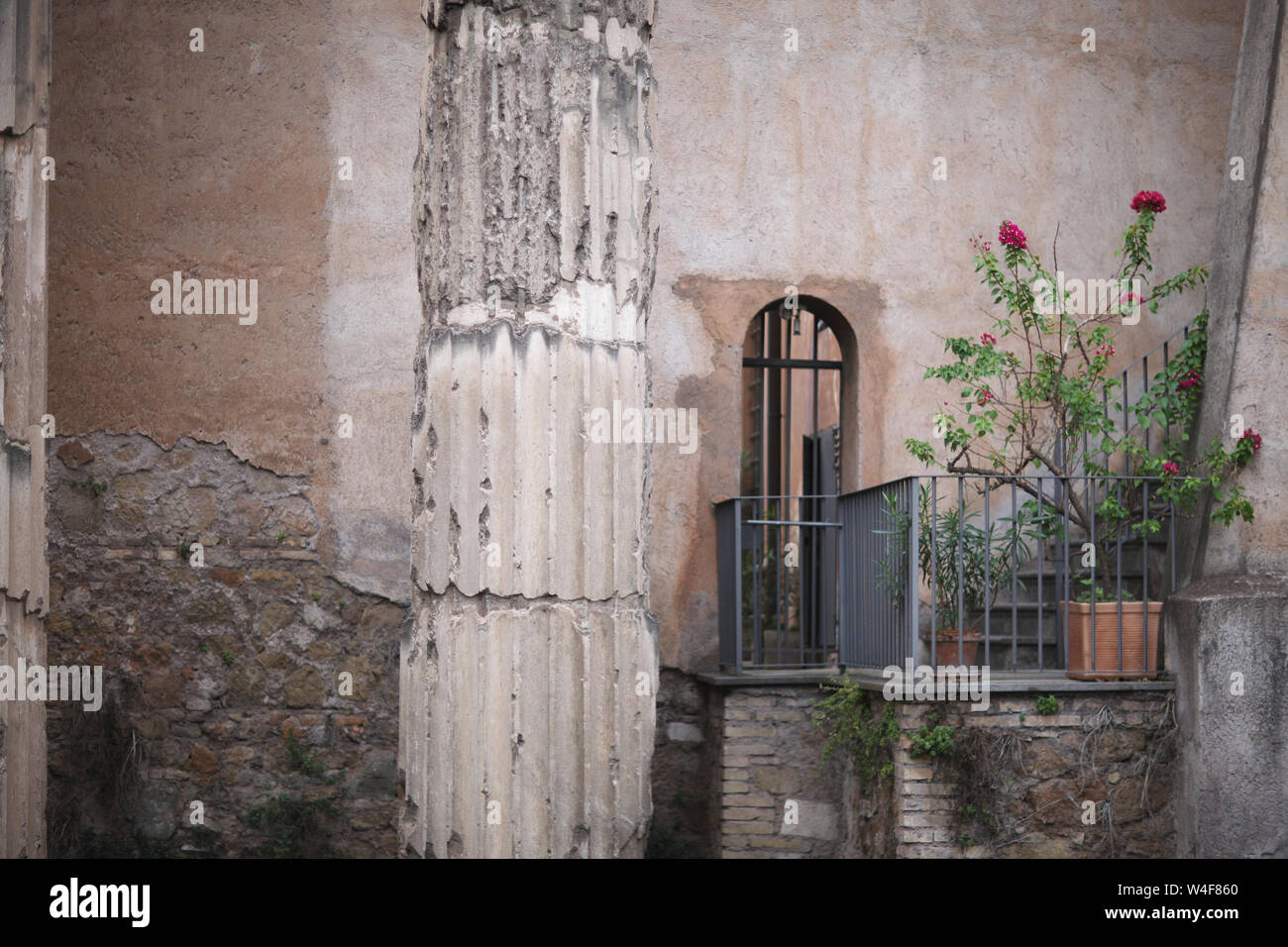 A small balcony with flowers in pots in a medieval building. Rome ...