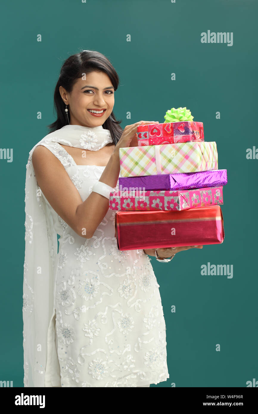 Woman holding gift boxes and smiling Stock Photo - Alamy
