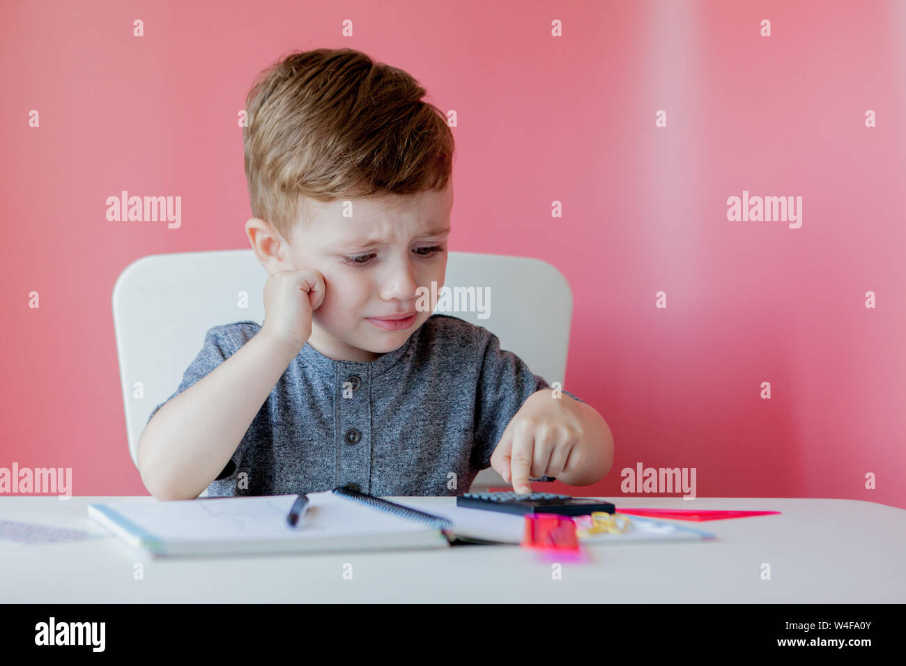 Portrait of cute kid boy at home making homework. Little concentrated ...