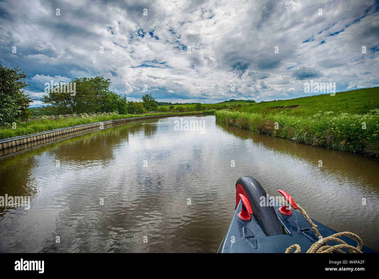 View from the bow of narrowboat traveling through English rural ...