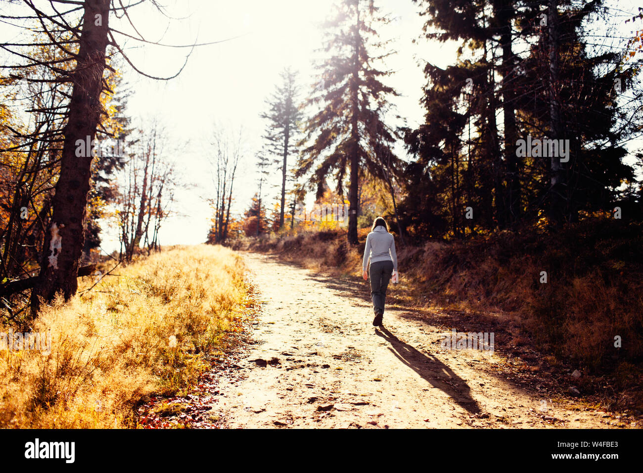 Autumn in mountain. Young woman walking uphill Stock Photo - Alamy
