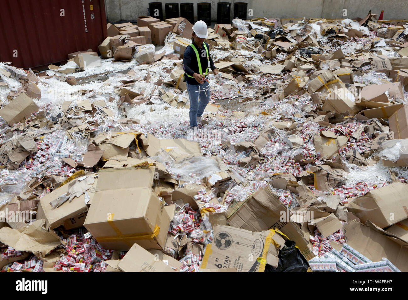 Manila, Philippines. 23rd July, 2019. A worker walks among confiscated ...