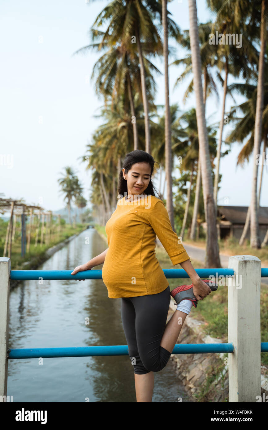 pregnant woman stretch her leg during exercising outdoor Stock Photo ...