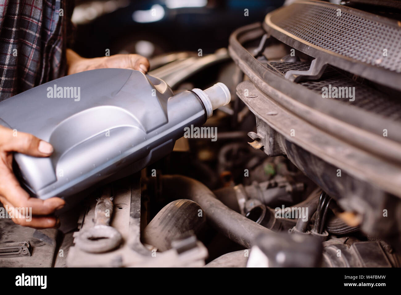 Car mechanic fills engine oil Stock Photo - Alamy