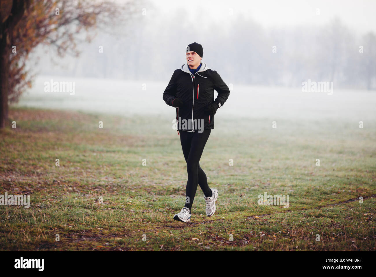 Winter runner. Man running in the park at cold morning Stock Photo - Alamy