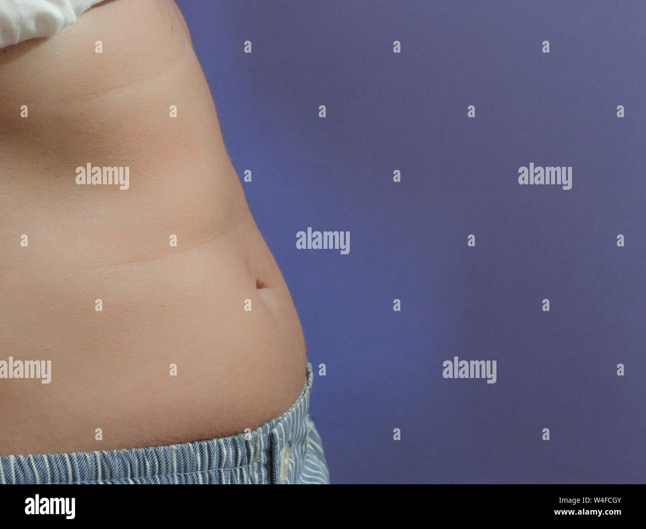 Belly of a woman on purple background with copy space Stock Photo - Alamy
