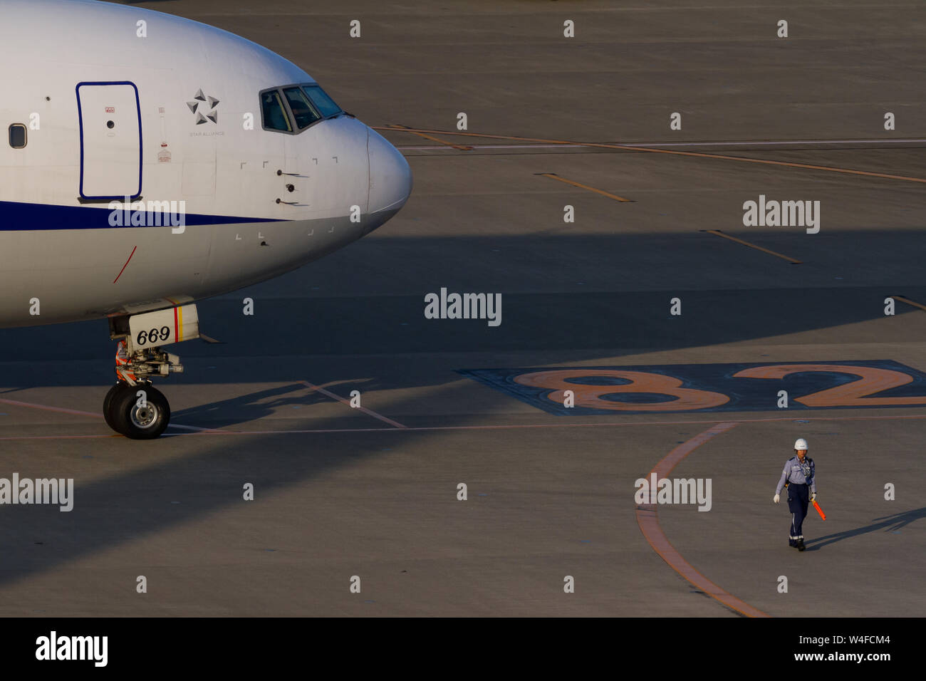 A man directs an All Nippon Airways (ANA) Boeing 767-381(ER) at Haneda ...