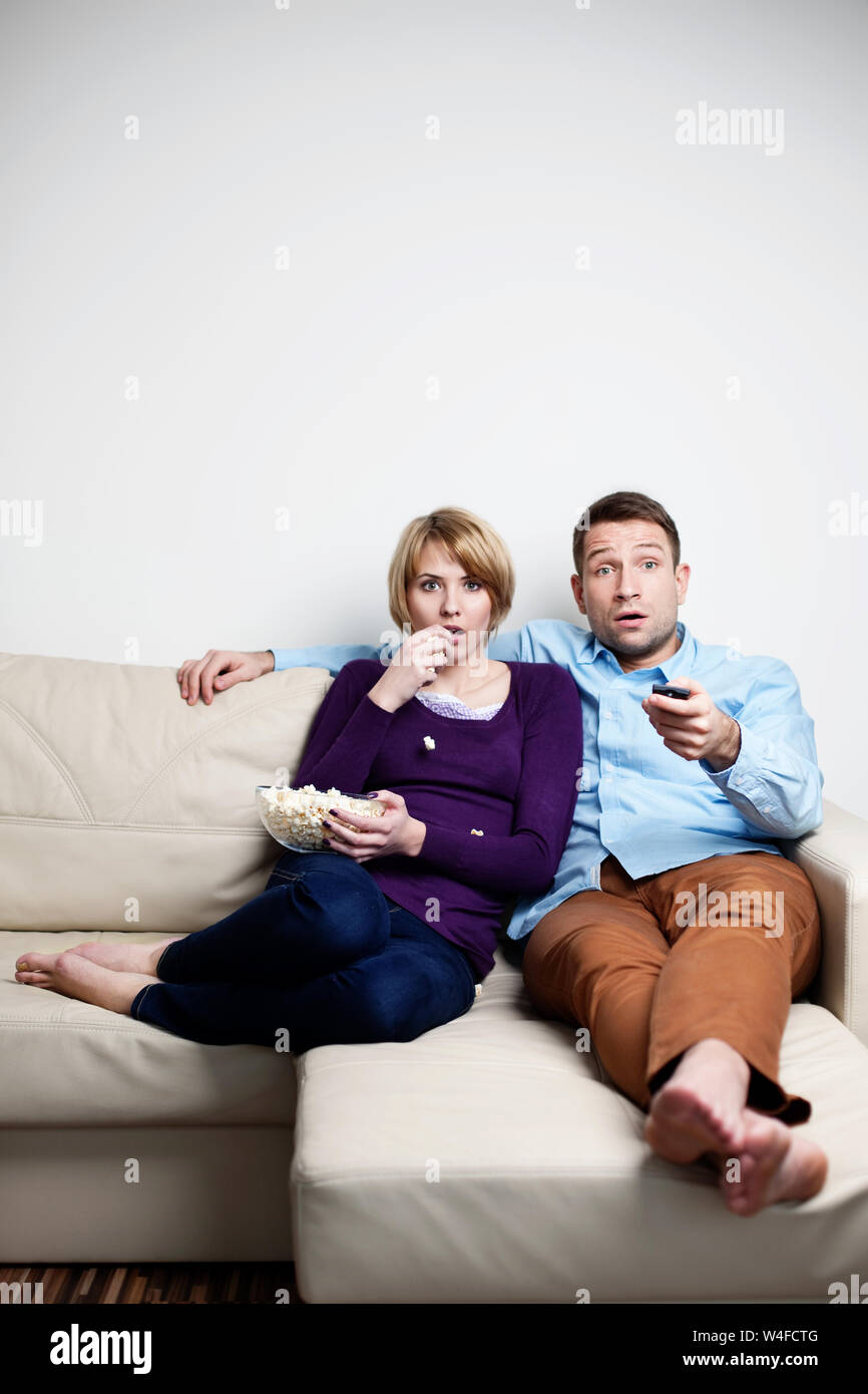 Scared young couple watching tv Stock Photo - Alamy