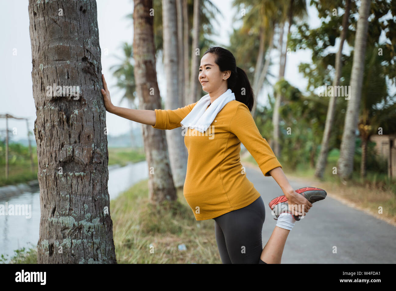 pregnant woman stretch her leg during exercising outdoor Stock Photo ...