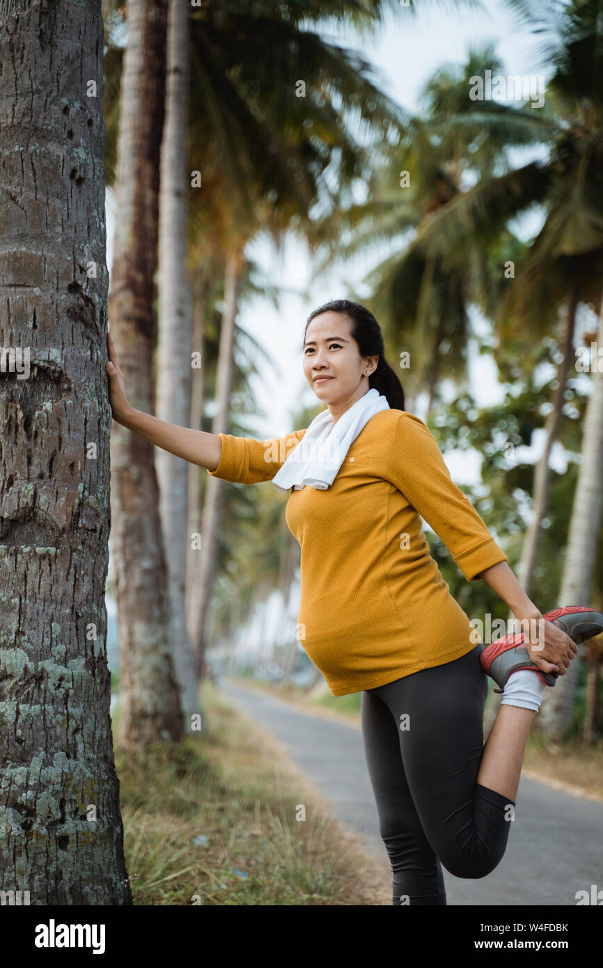 pregnant woman stretch her leg during exercising outdoor Stock Photo ...