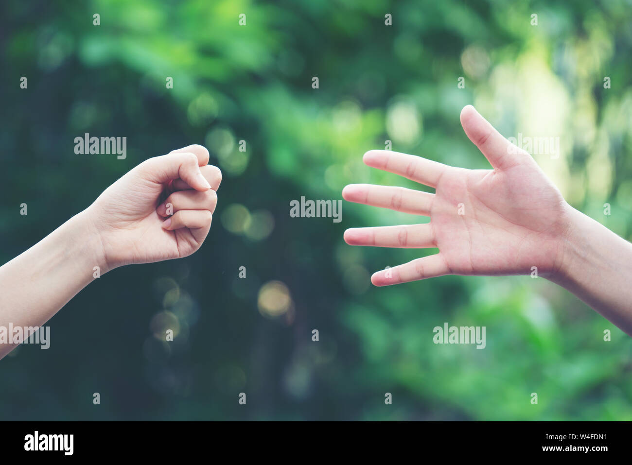 Couple play rock paper scissors hand game nature green background Stock ...