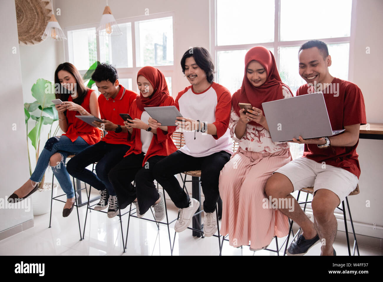 young people sitting together using their own gadget Stock Photo - Alamy