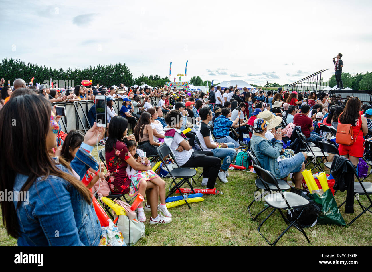 A crowd watches as an artist performs live on stage at a Filipino ...