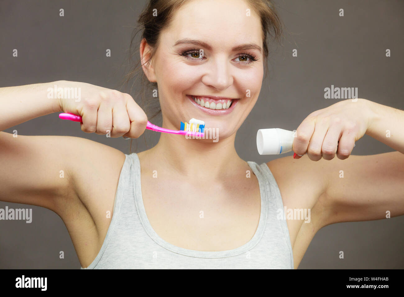 Woman holding toothbrush and placing toothpaste on it. Dental health ...
