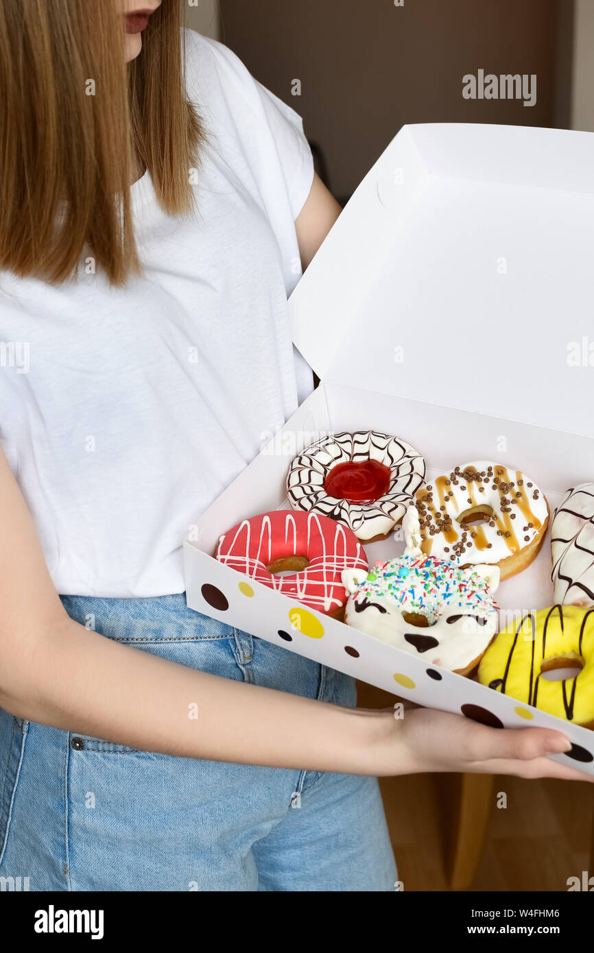 Young woman holding box of delicious donuts. Party concept. No diet ...