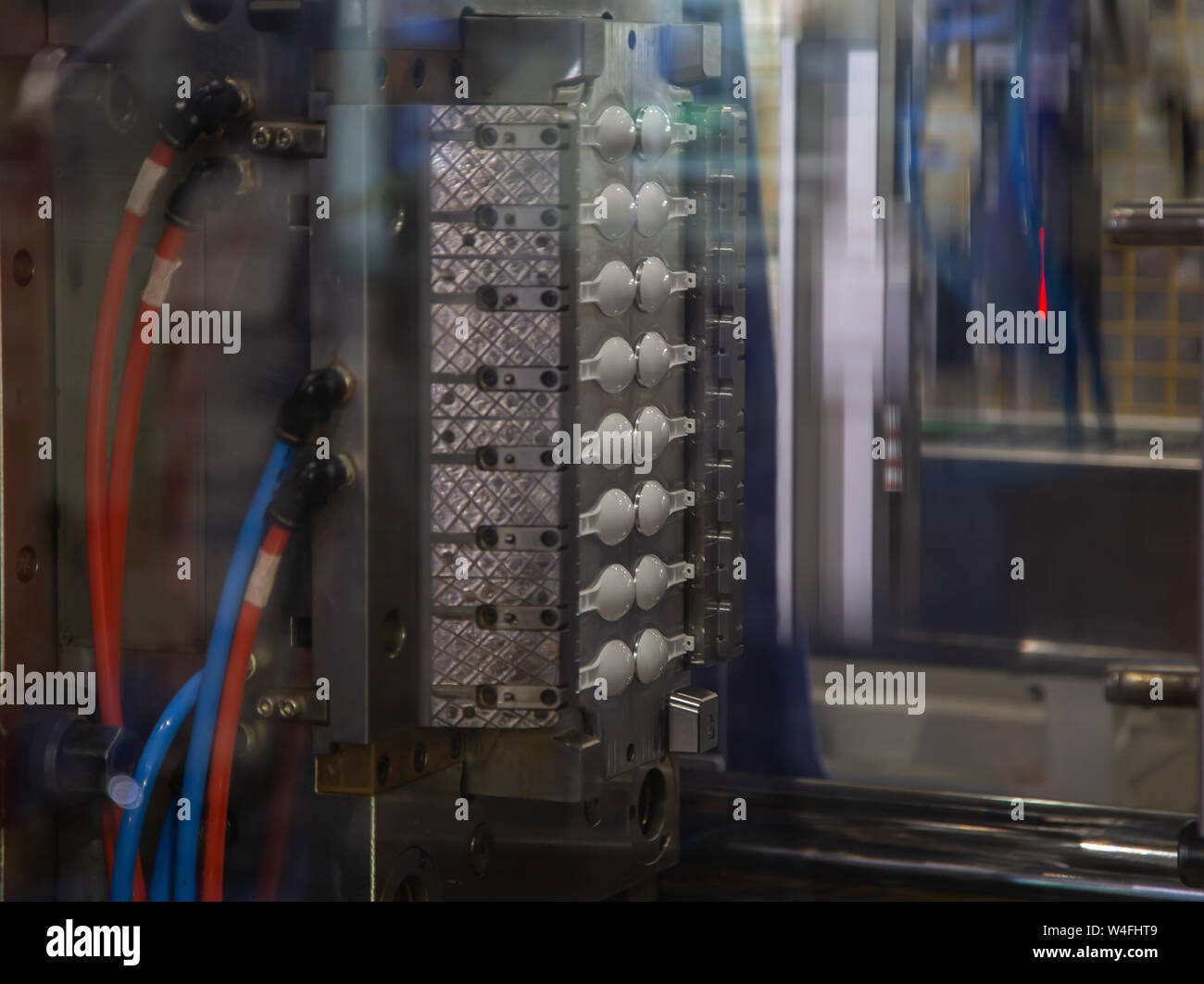 Close-up of plastic spoon product on injection molding press machine ...