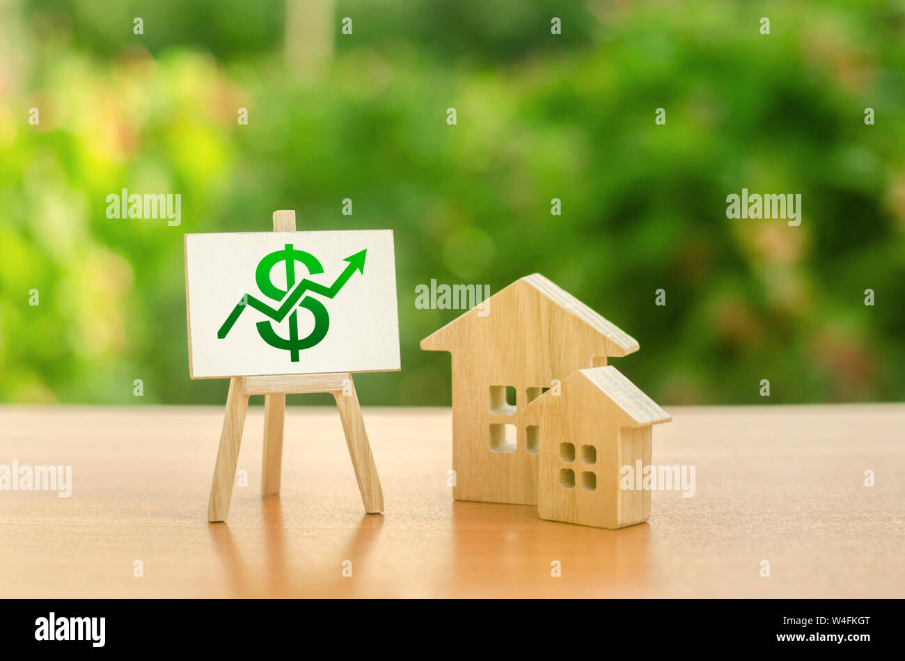 Two wooden houses and a green up arrow on the sign. Real estate value ...