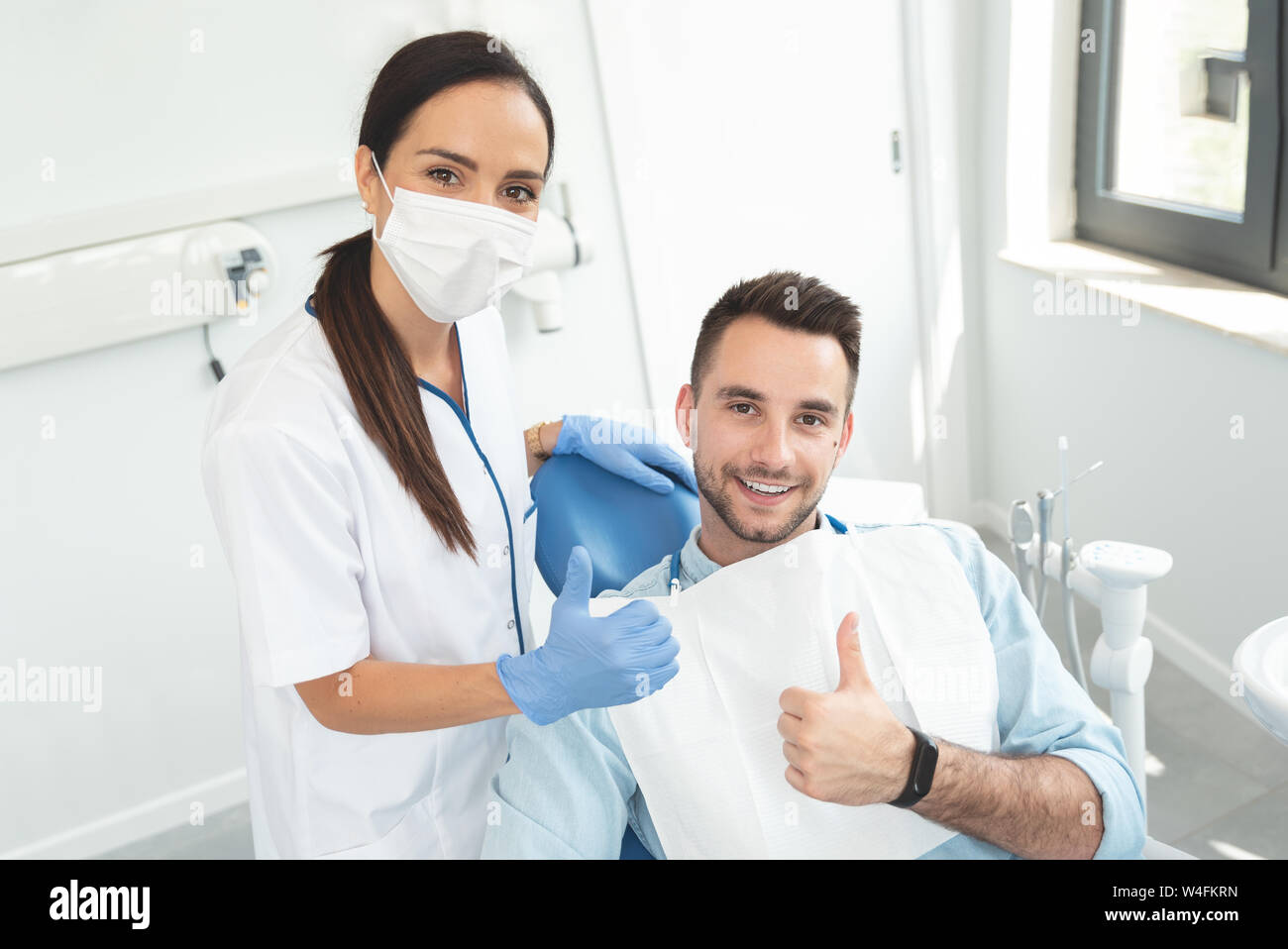 Young doctor dentist and patient showing thumb up. Healthy teeth ...