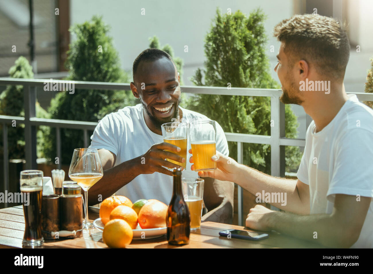 Young group of friends drinking beer, having fun, laughting and ...