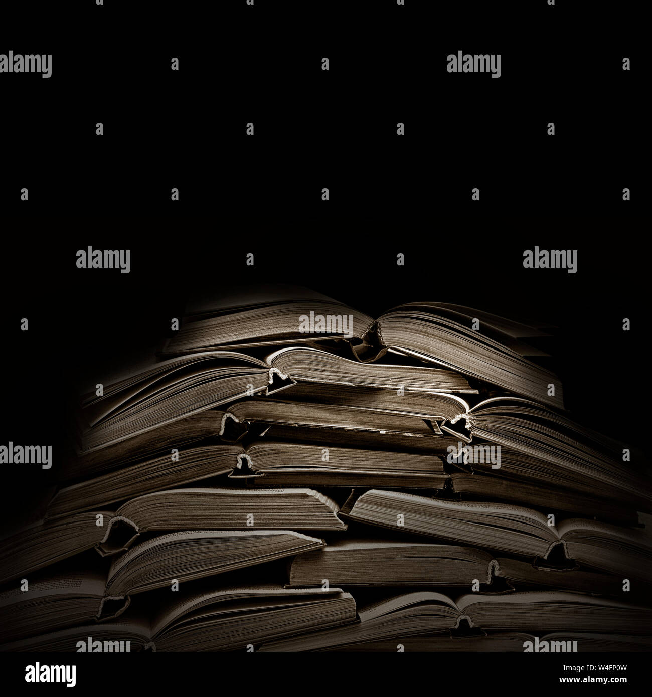 stack of open old books in black background Stock Photo - Alamy