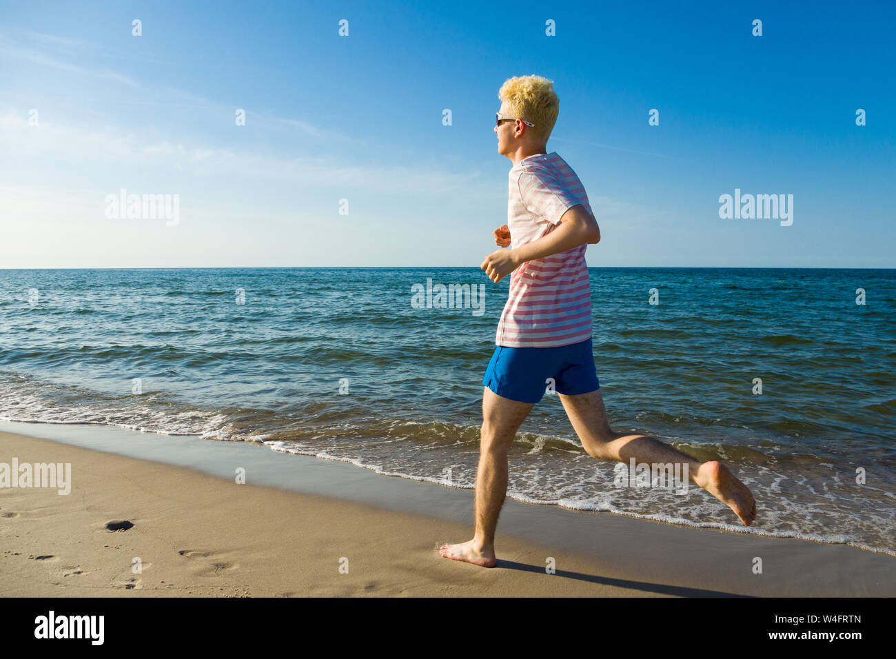 Man running, jumping on beach Stock Photo - Alamy