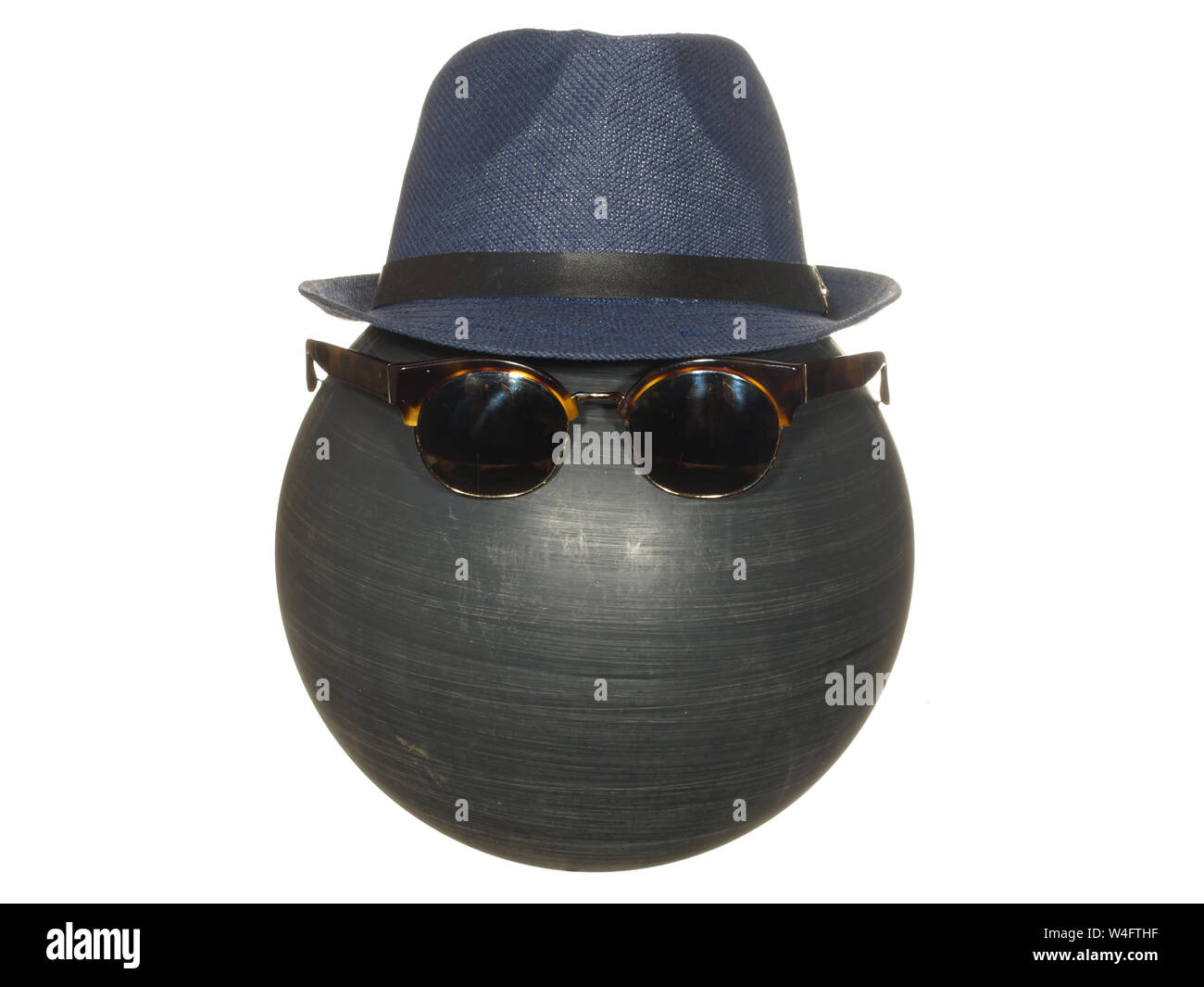 Men's blue hat and dark goggles on a black plastic ball isolated on ...