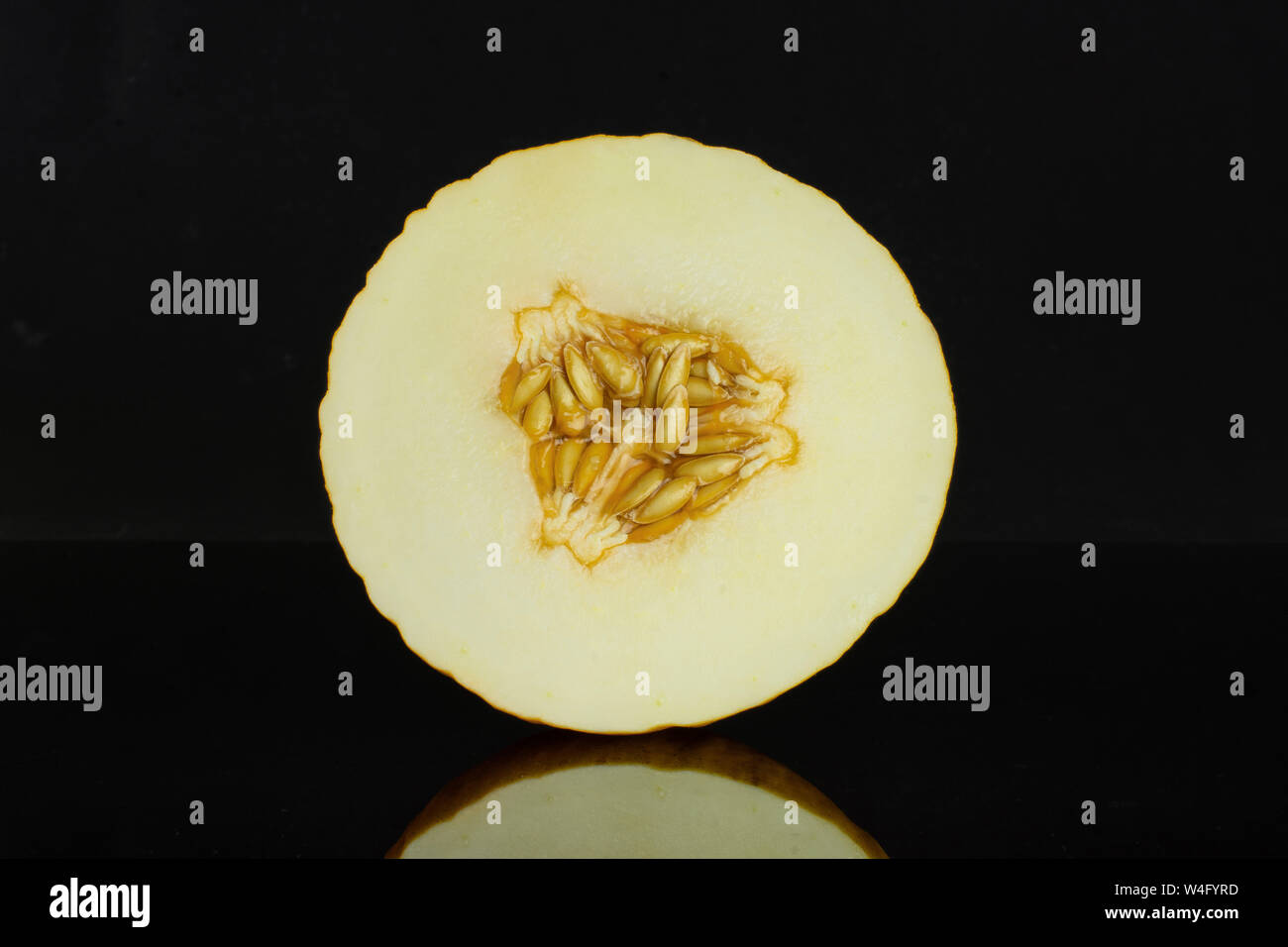 One half of fresh yellow melon canary cross section isolated on black ...
