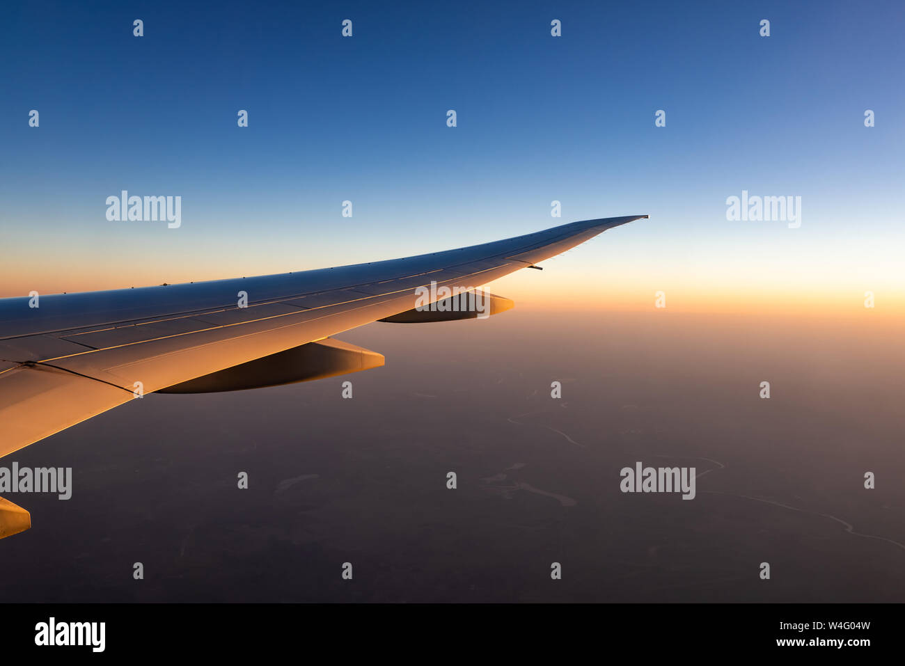 Wing of plane over the city. Airplane flying on blue sky. Scenic view ...