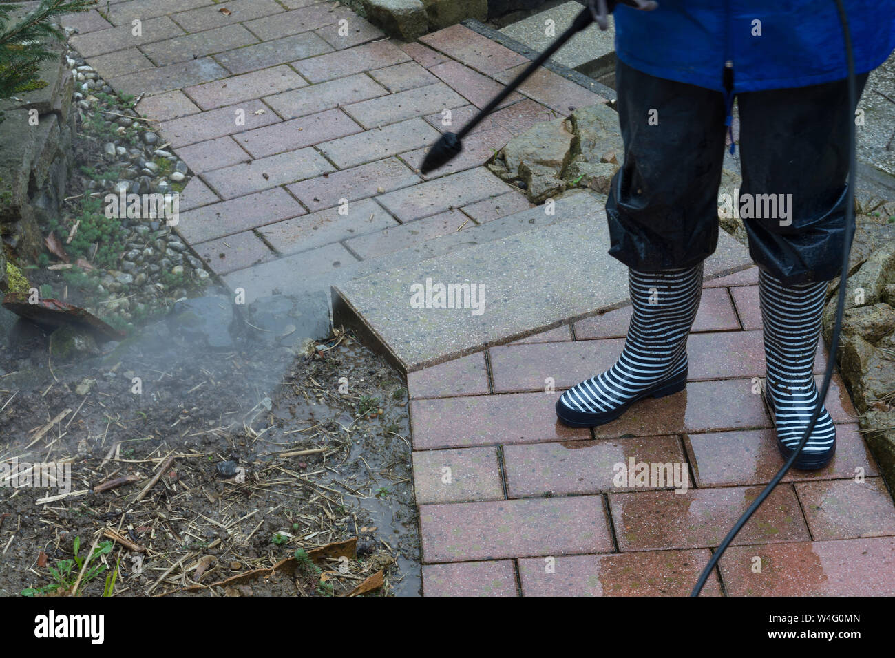 Woman cleans stone slabs with a pressure washer Stock Photo - Alamy