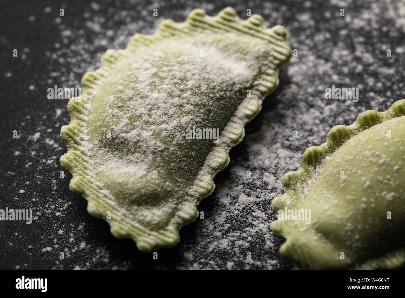 close up view of green fresh ravioli with flour on black surface Stock ...