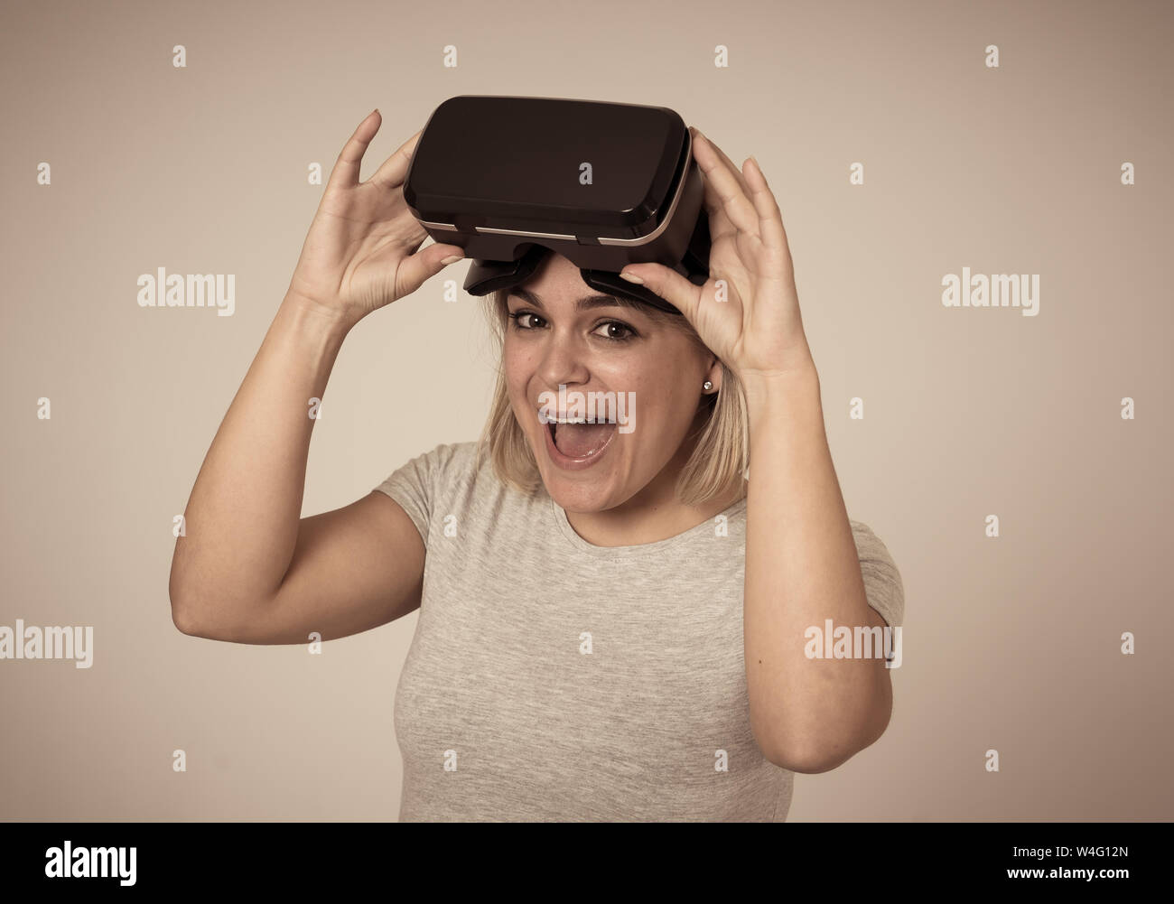 Curious woman happy and excited to use virtual reality goggles feeling ...