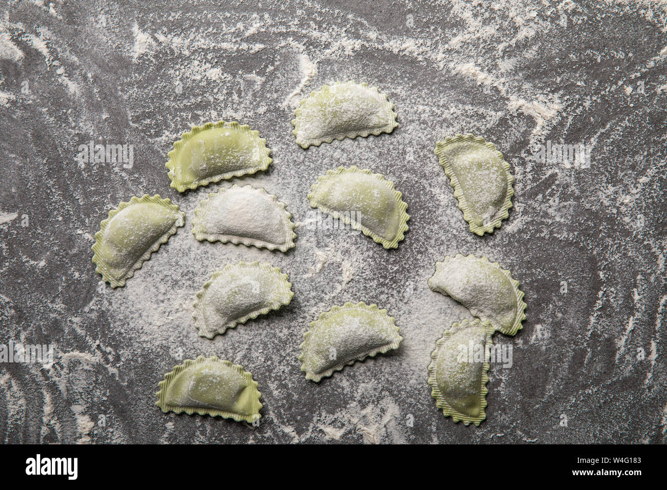 top view of raw green ravioli with flour on grey textured surface Stock ...