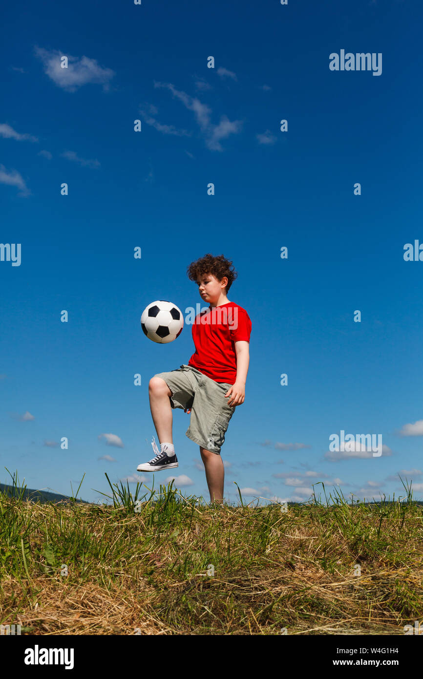 Boy playing football outdoor Stock Photo - Alamy