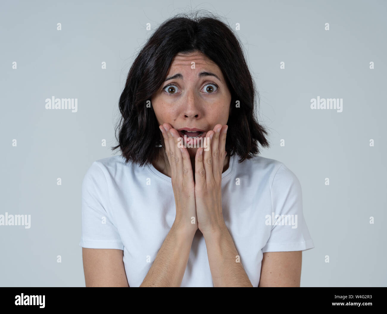 Close up of latin woman with frightened eyes, shocked making fear ...