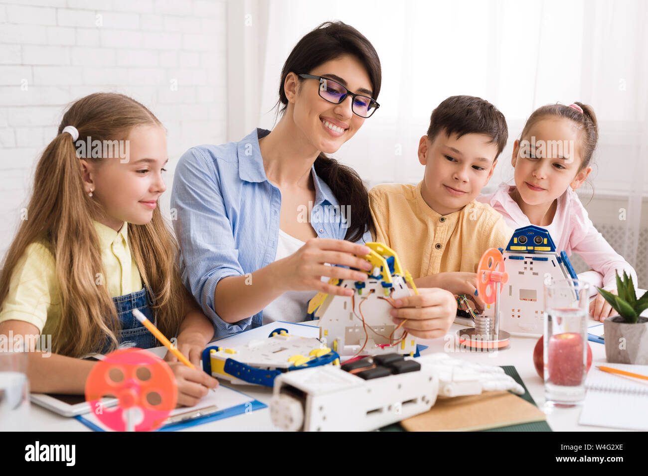Kids creating robots with teacher at stem education class Stock Photo ...