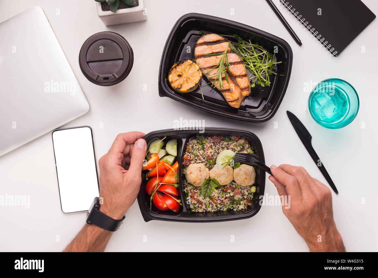 Man eating healthy food with grilled fish in office during lunch Stock ...