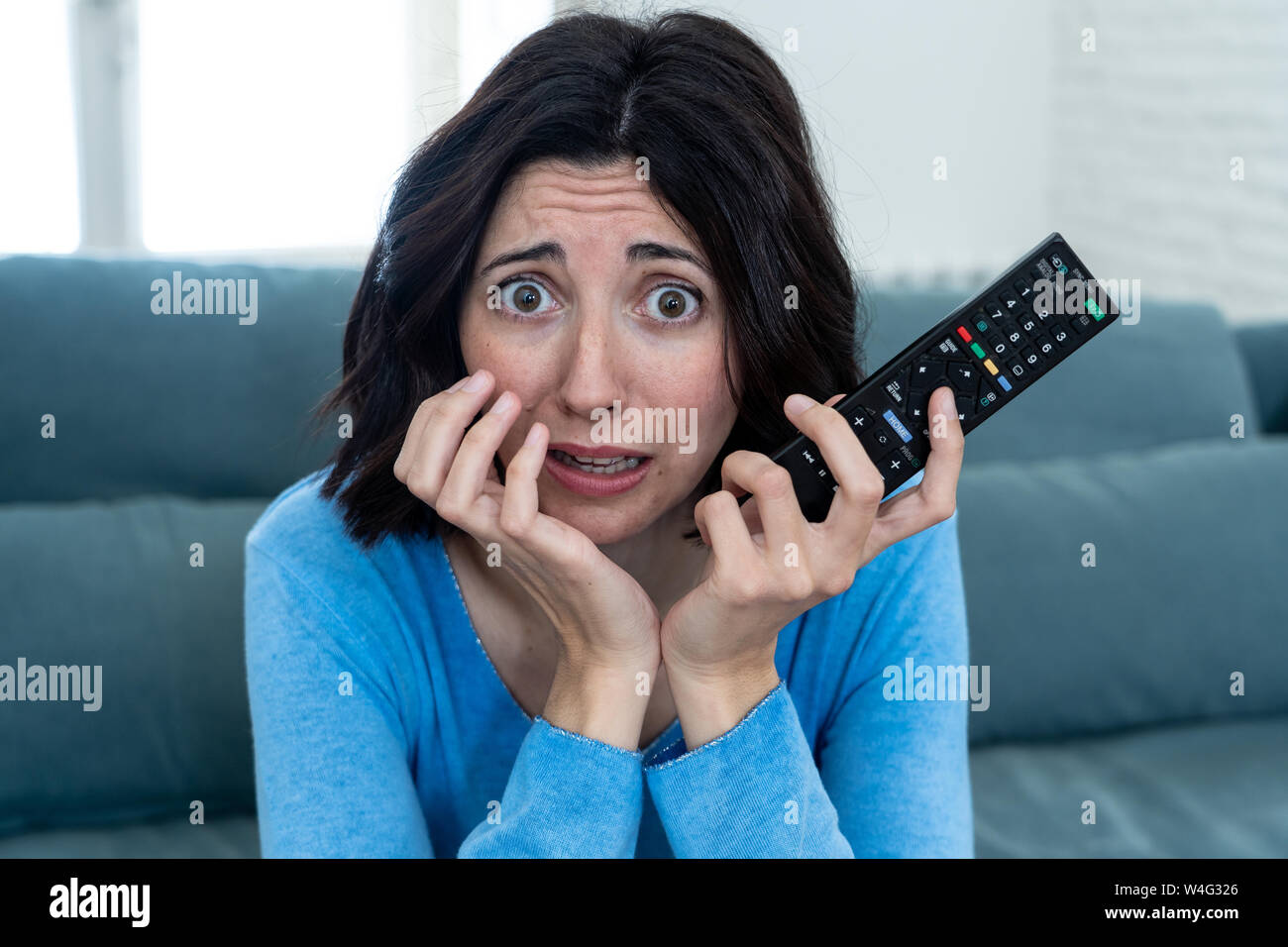 Scared woman on sofa watching tv hi-res stock photography and images ...