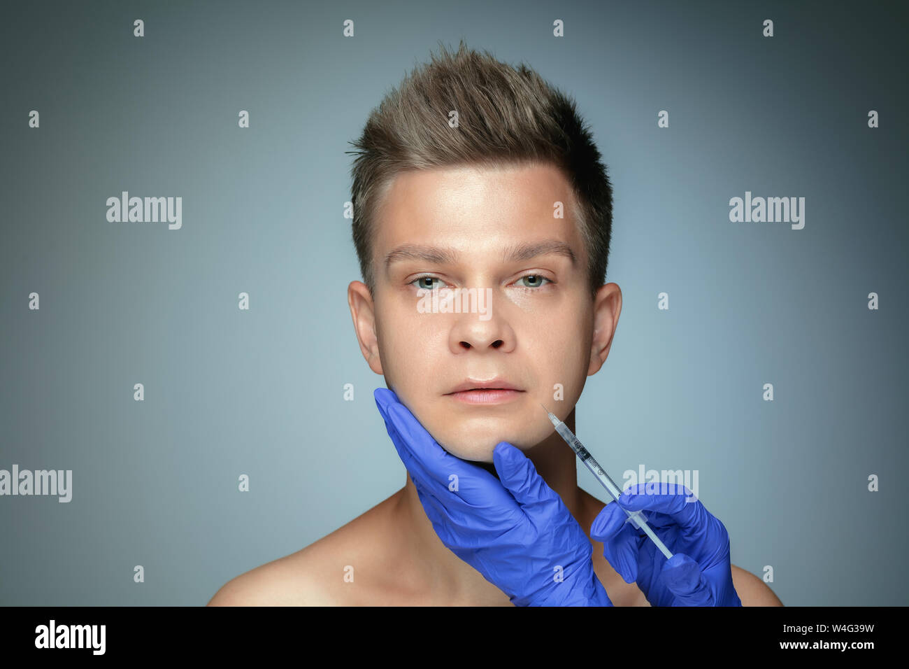 Close-up portrait of young man isolated on grey studio background ...