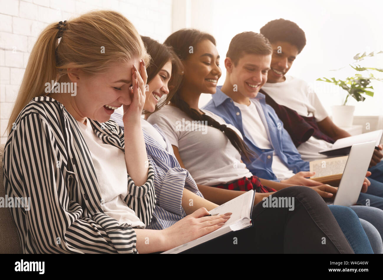 Positive students preparing for exams with books and laptop Stock Photo ...