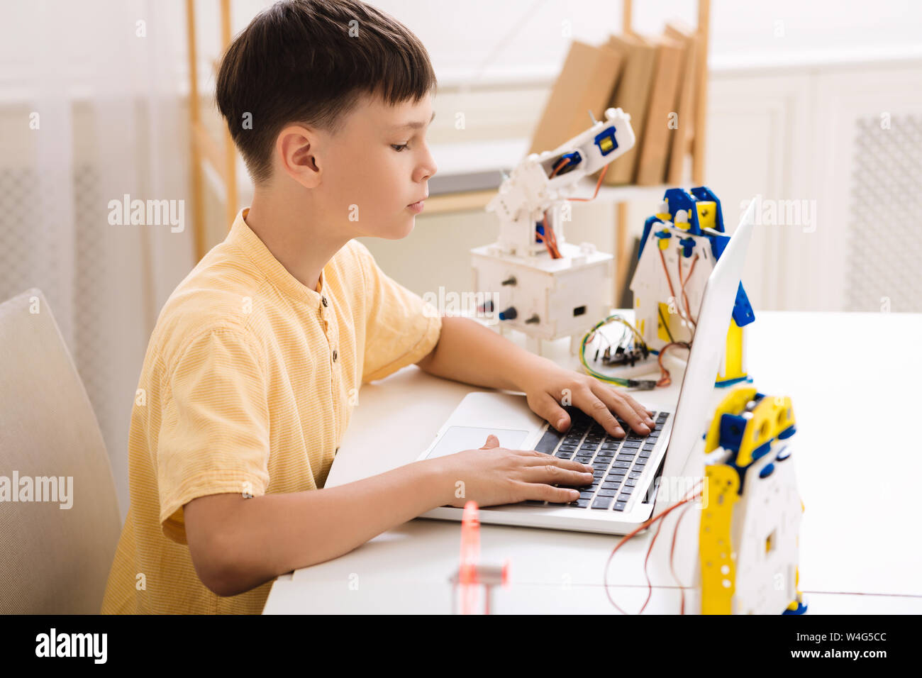 Boy creating robotics project on laptop in class Stock Photo - Alamy